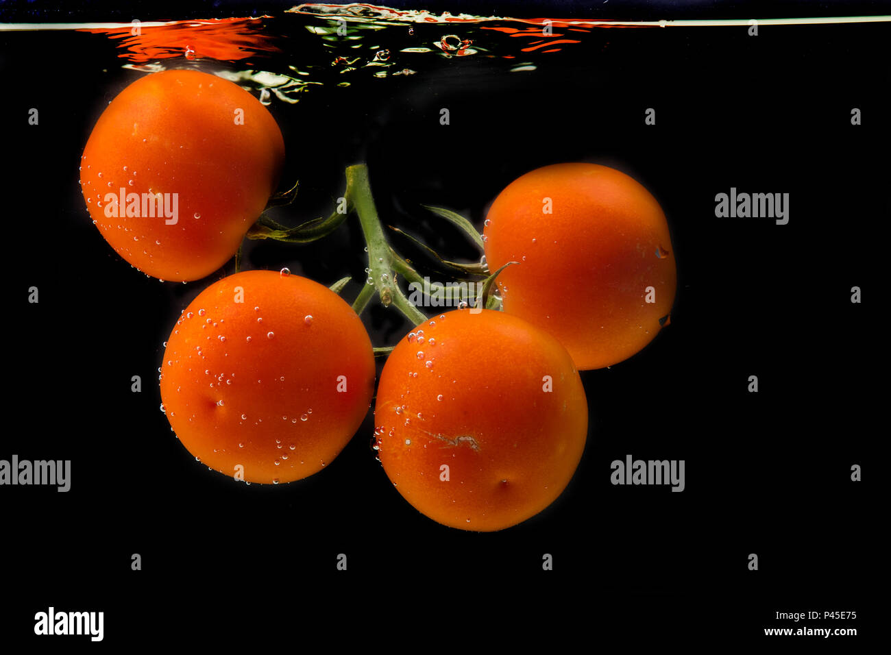Ripe tomatoes fall into the water. Splash of water Stock Photo - Alamy