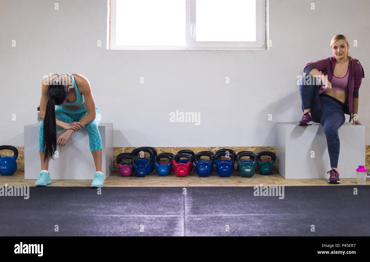 young athletes women sitting relaxing after exercise at cross fitness ...