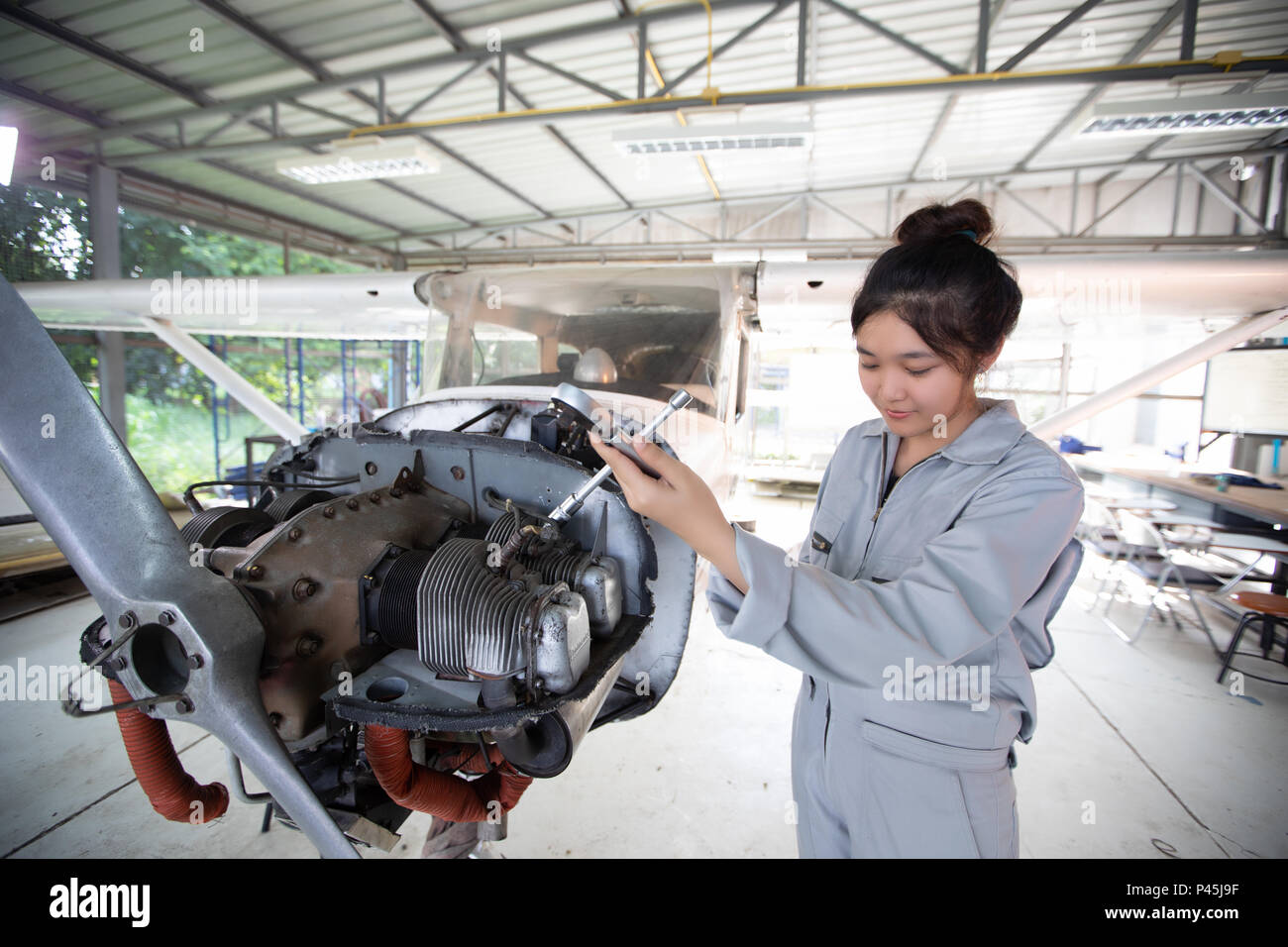 Asian men and women Engineers and technicians are repairing aircraft ...
