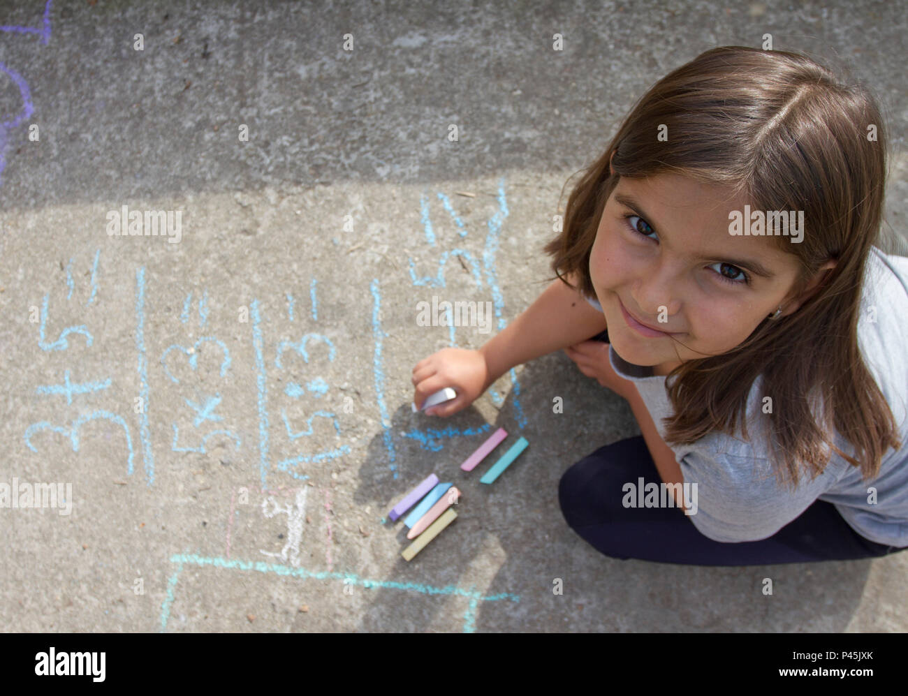 Girl kid thinking, writing and counting on mathematical equations with ...