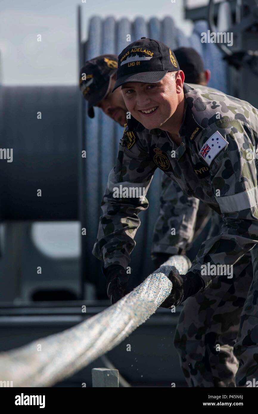 Australian sailor Seaman Zachary Putyra, boatswain mate, helps to ...