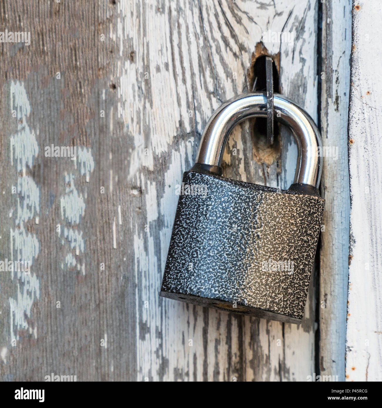 Small lock on an old wooden door Stock Photo - Alamy