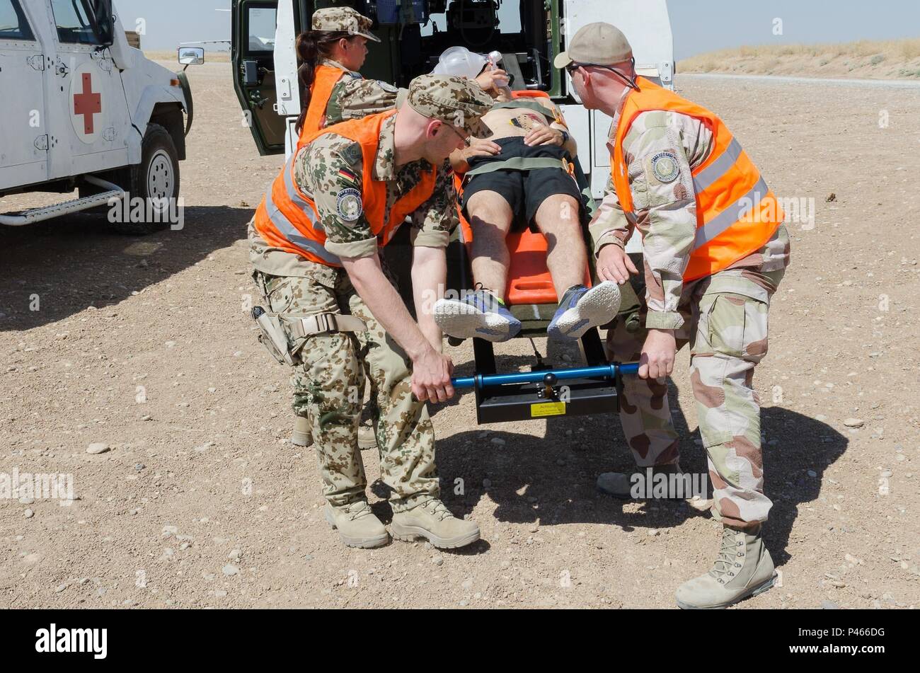 Coalition partners load a simulated casualty into an armored ambulance ...