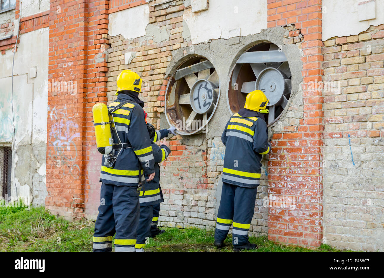 View from behind on team of firefighters in uniform with full safety ...
