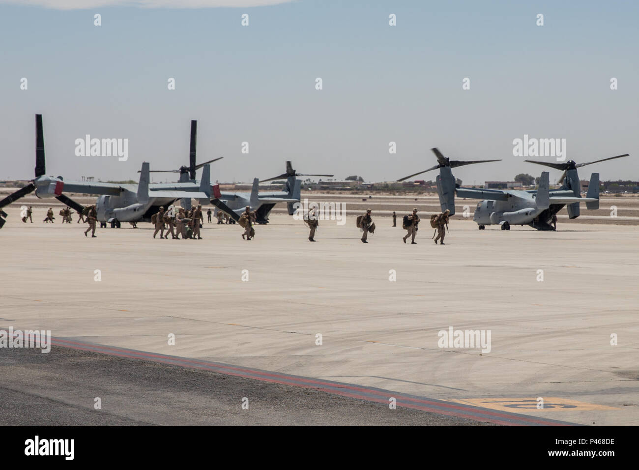 Marines walk to several MV-22 Ospreys to move out to a forward staging ...
