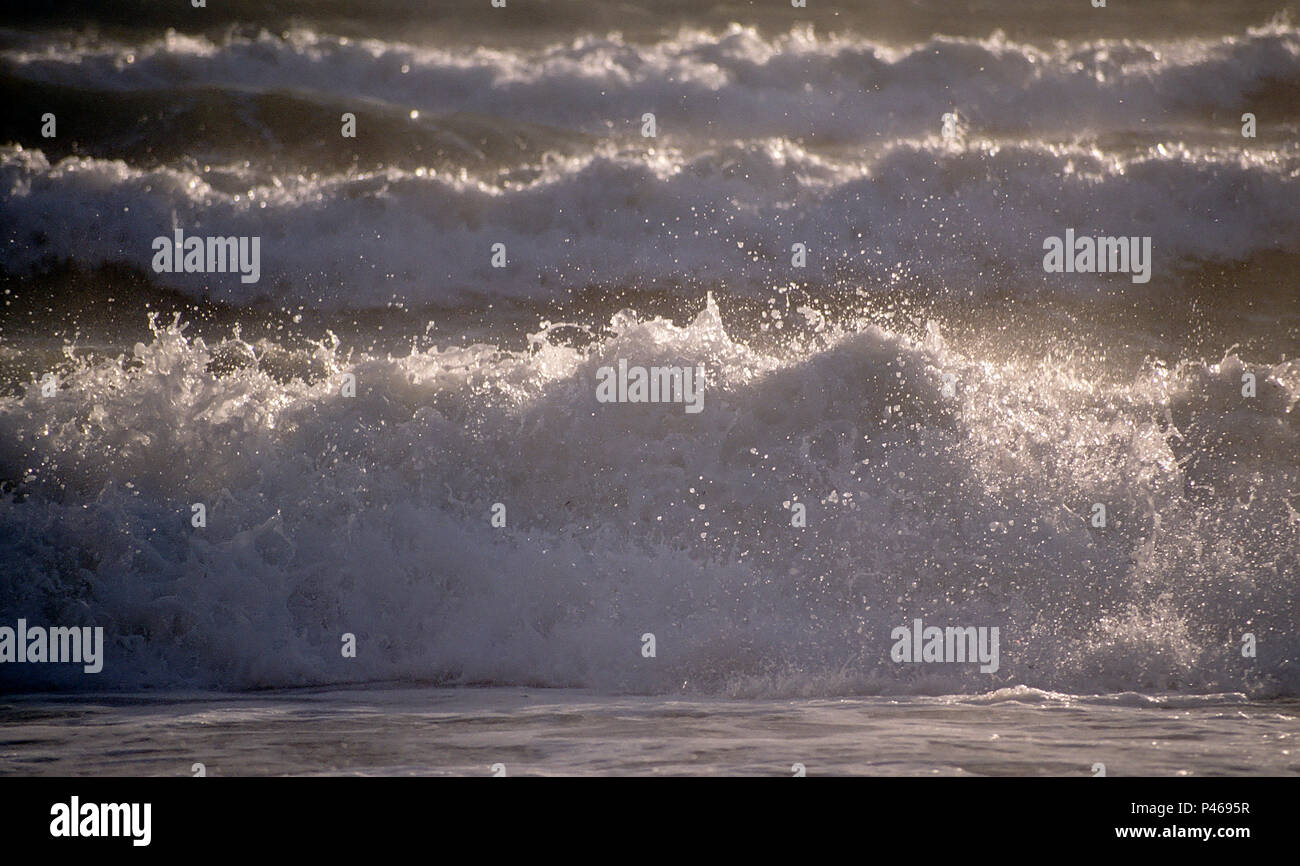 Sunlit waves on a beach Stock Photo - Alamy