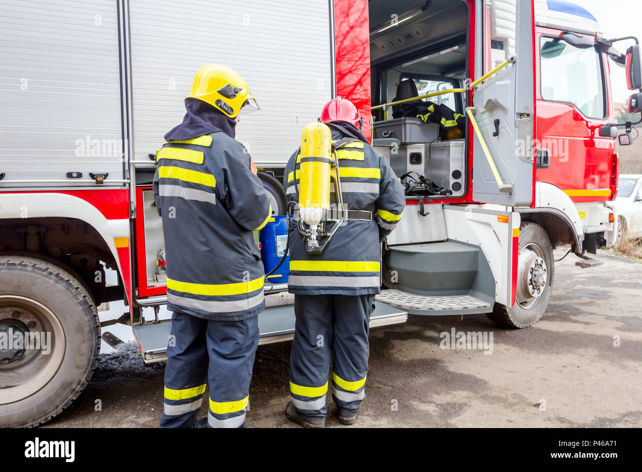 Firefighter is helping fellow to assembly his gear, keep balance and ...