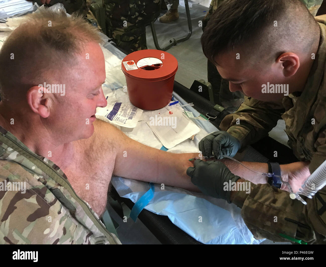 Spc. Joseph Porter, applies an intravenous line to the antecubital vein ...