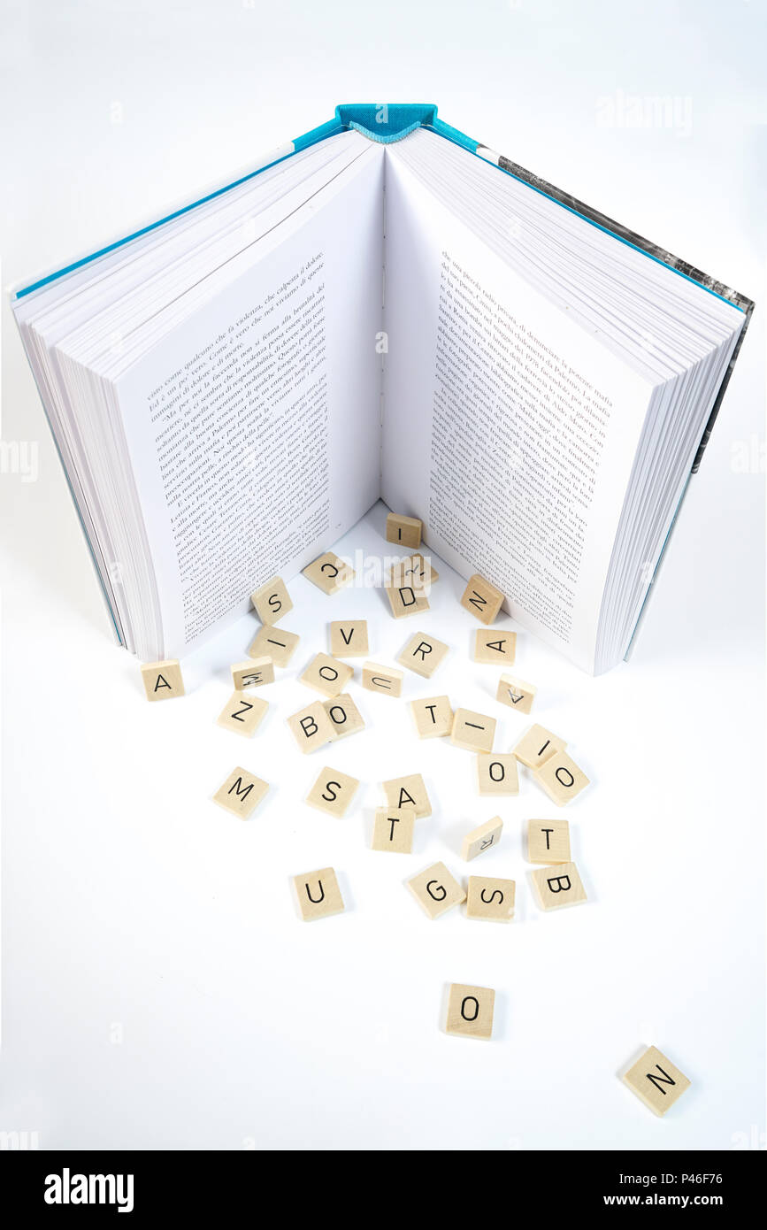 letters falling from a book on a white table Stock Photo - Alamy
