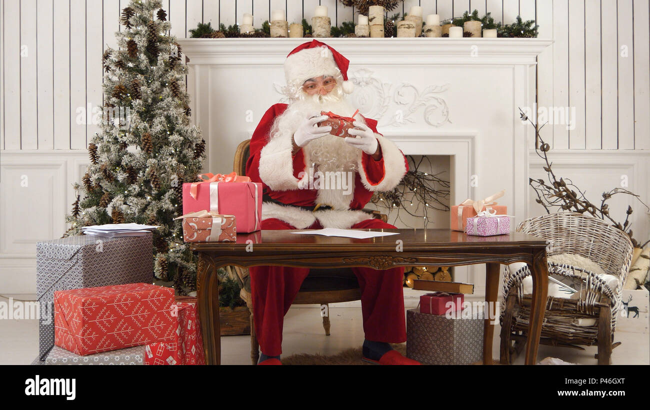 Santa Claus checking his list of presents Stock Photo - Alamy