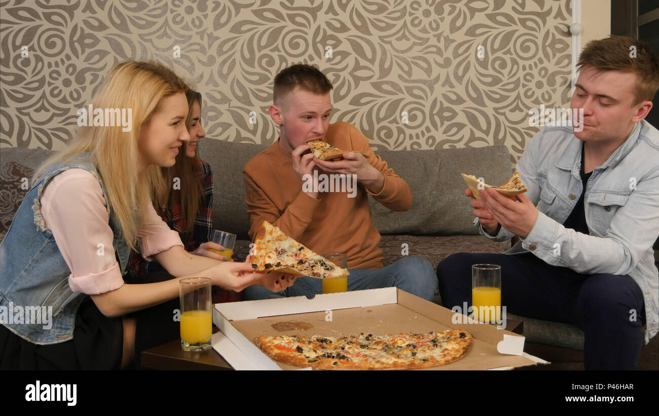 Young people in casual clothes eating pizza, talking, laughing Stock ...