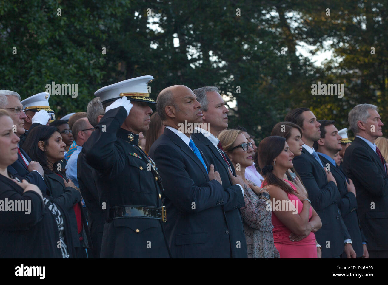 Guests stand for the National Anthem during a sunset parade at the ...