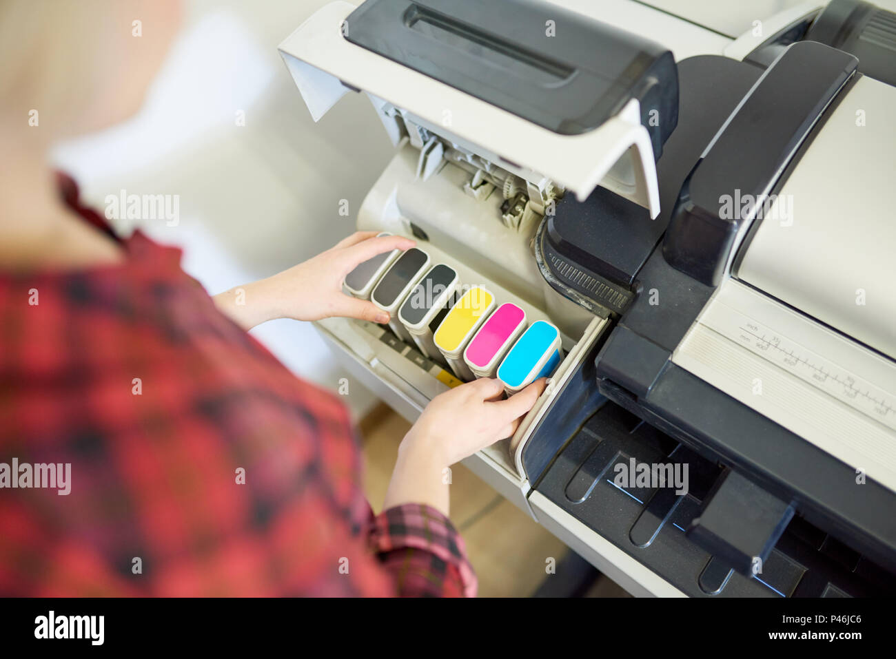 Crop woman putting ink in printer Stock Photo - Alamy