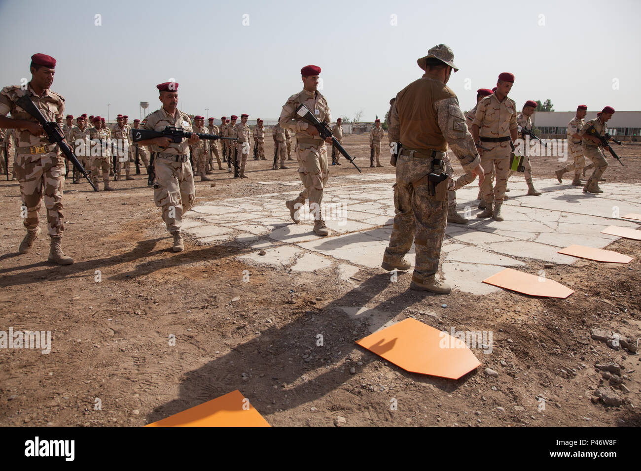 Iraqi soldiers move forward to disassemble their M16 rifles during a ...