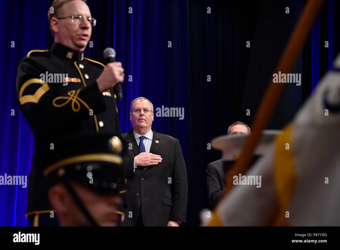 Deputy Secretary of Defense Bob Work renders honors as an Army vocalist ...