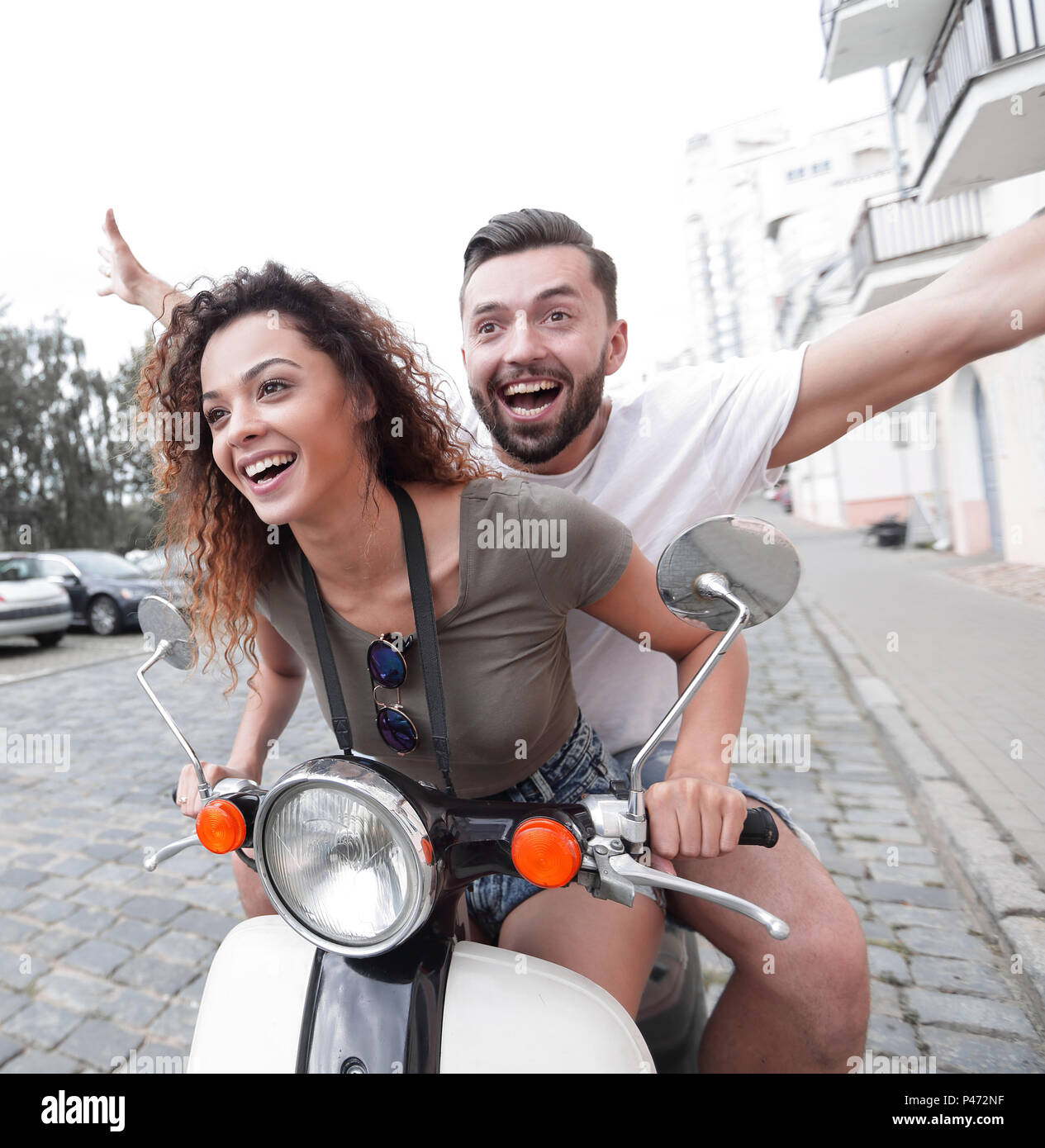 Couple riding motor scooter in old city street Stock Photo - Alamy