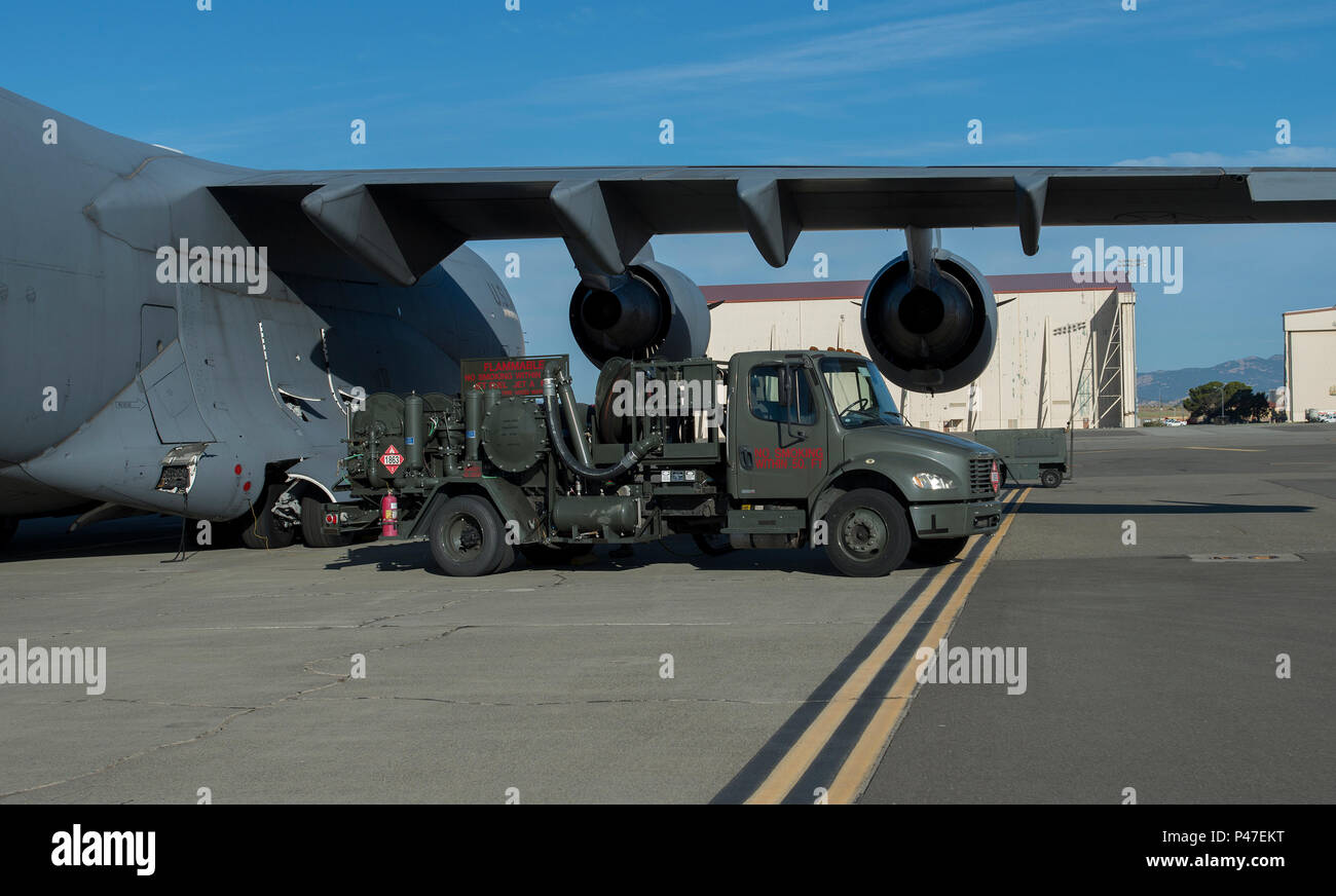 A R-12 Refueler Mobility Unit (R-12) parked under the wing of a C-17 ...