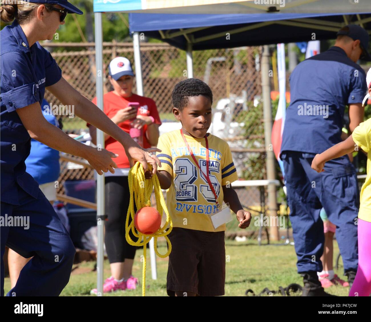 A Coast Guard member from Station Honolulu helps a student throw ...