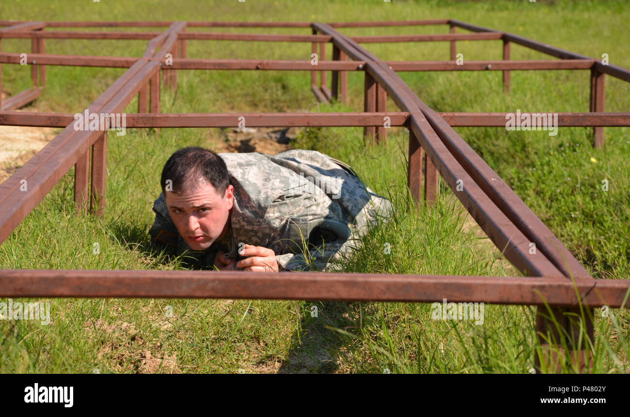 Spec. David Dorfman maneuvers the Low Crawl Pit of the obstacle course ...