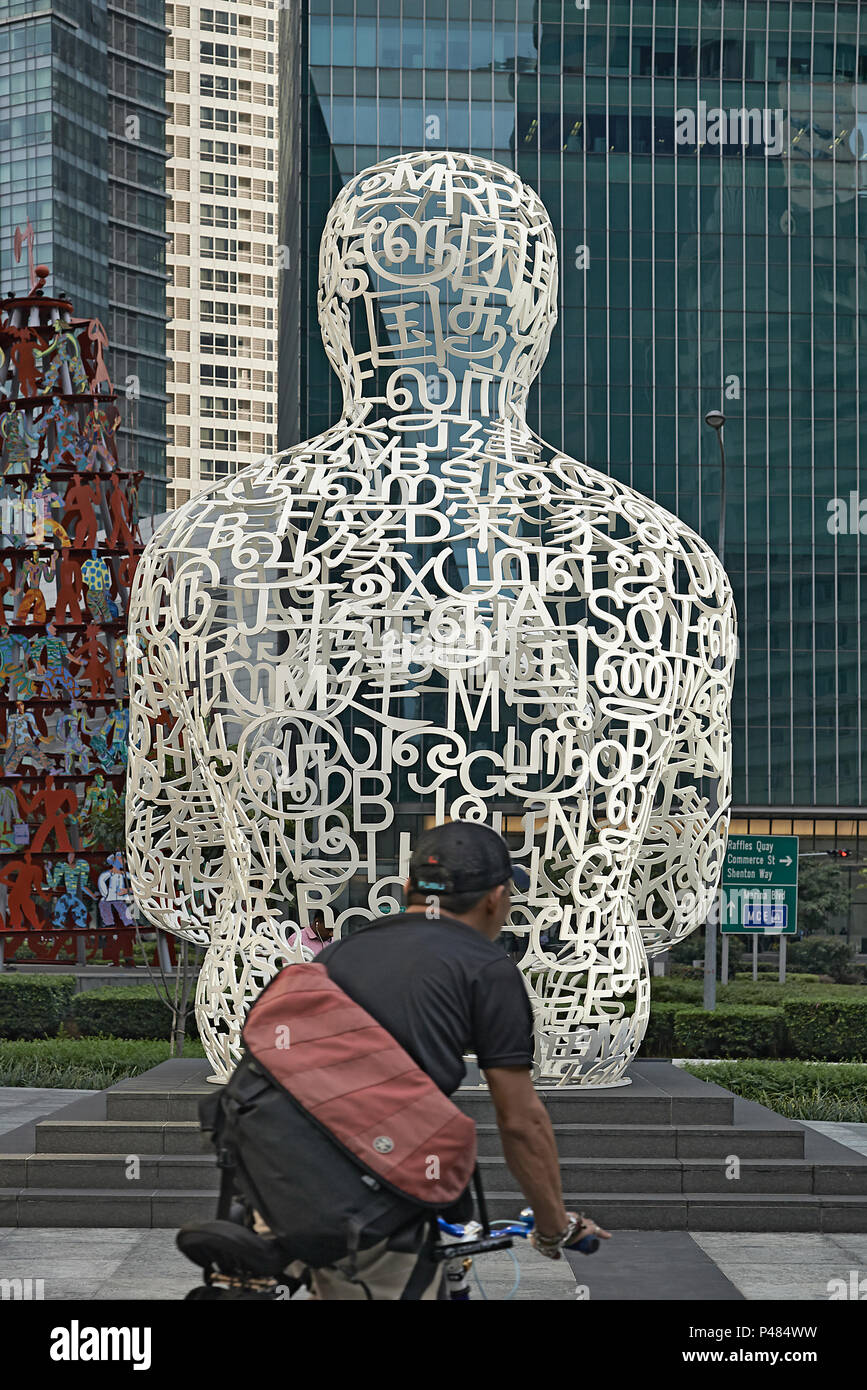 A bike courier cycling past a statue of a man made out of letters and ...