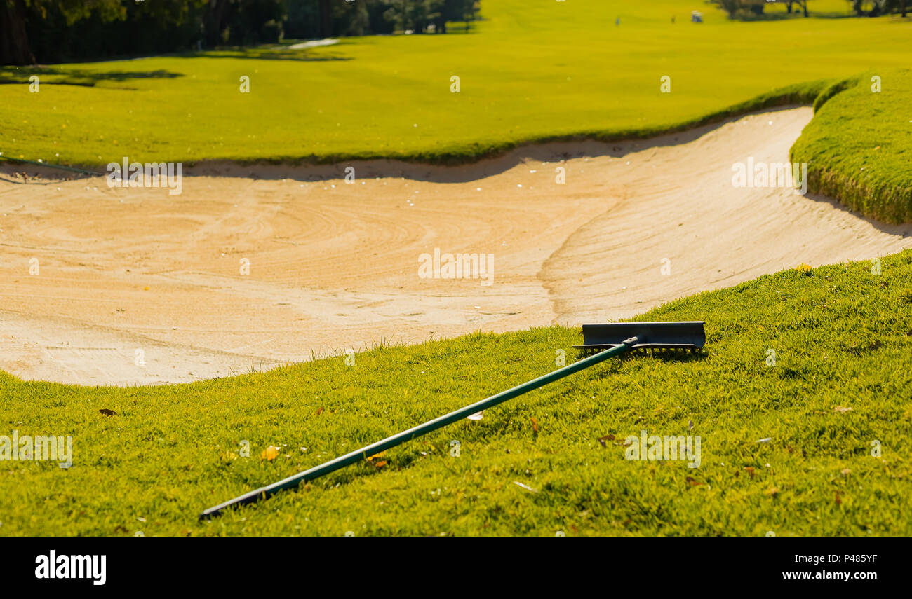 Sand Bunker Hazard and rake on Golf Course Fairway in afternoon light ...