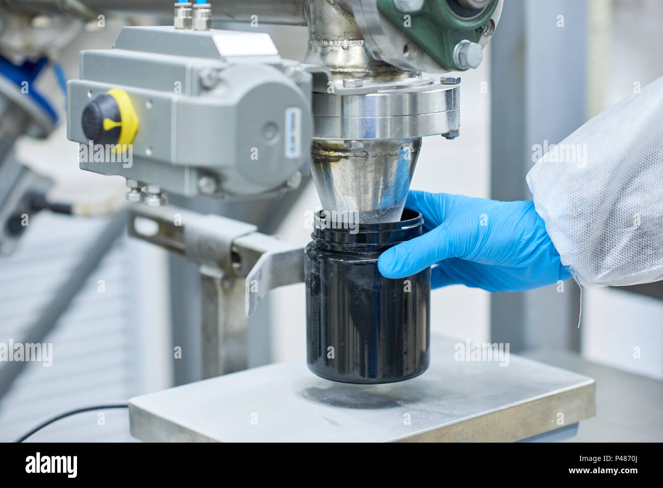 Factory worker filling plastic jar with product Stock Photo - Alamy