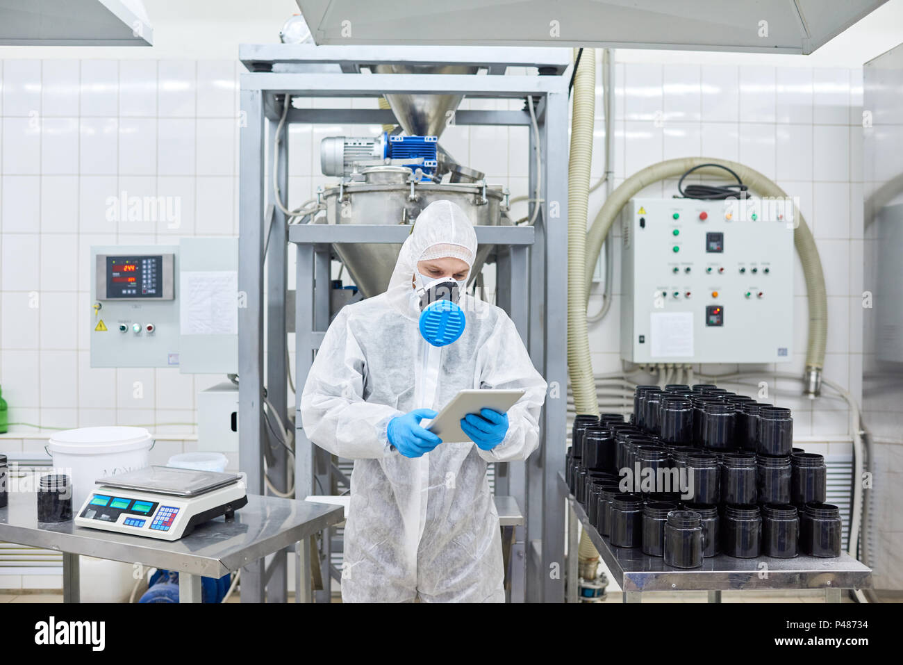 Factory worker standing and using tablet Stock Photo - Alamy
