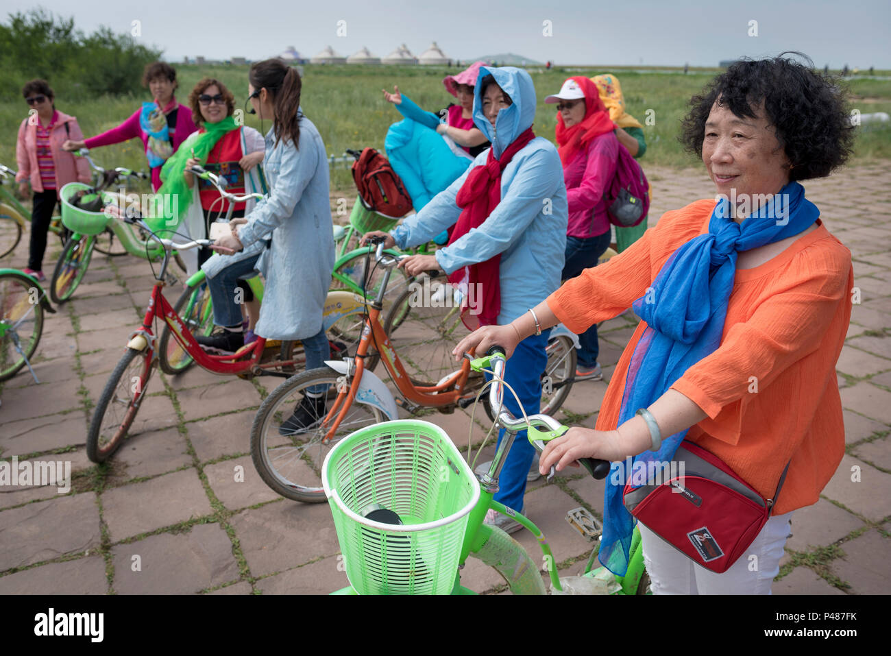 Middle aged women on bicycles prepare to visit the Yan Dynasty Imperial ...