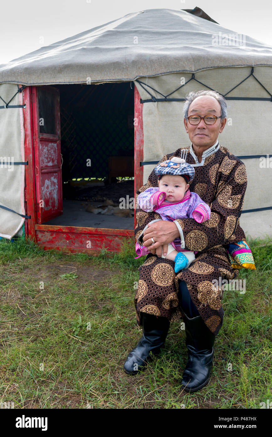 Grandfather with infant grandson outside their summertime yurt ...