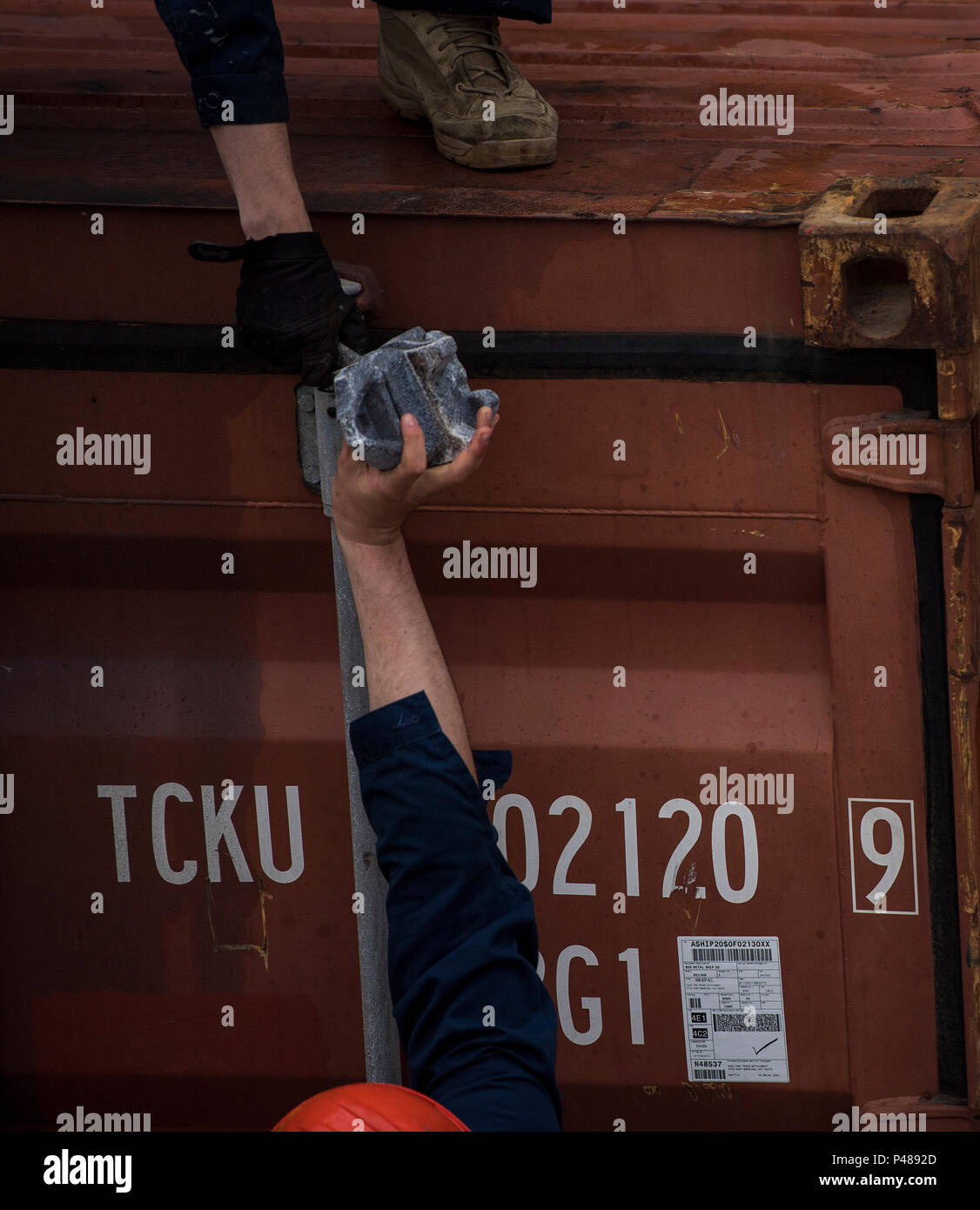 U.S. Army soldiers prepare cargo containers for unloading on a vessel ...