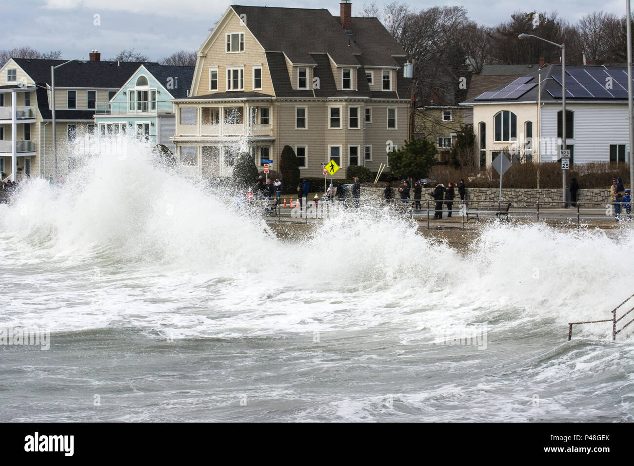 Folks are getting wet from the high surf of the waves during a storm ...