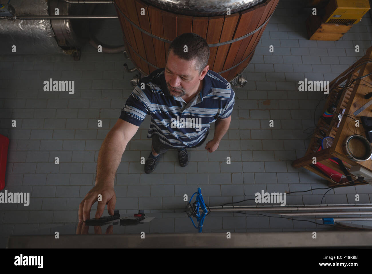 Male worker monitoring a pressure gauge of storage tank Stock Photo - Alamy
