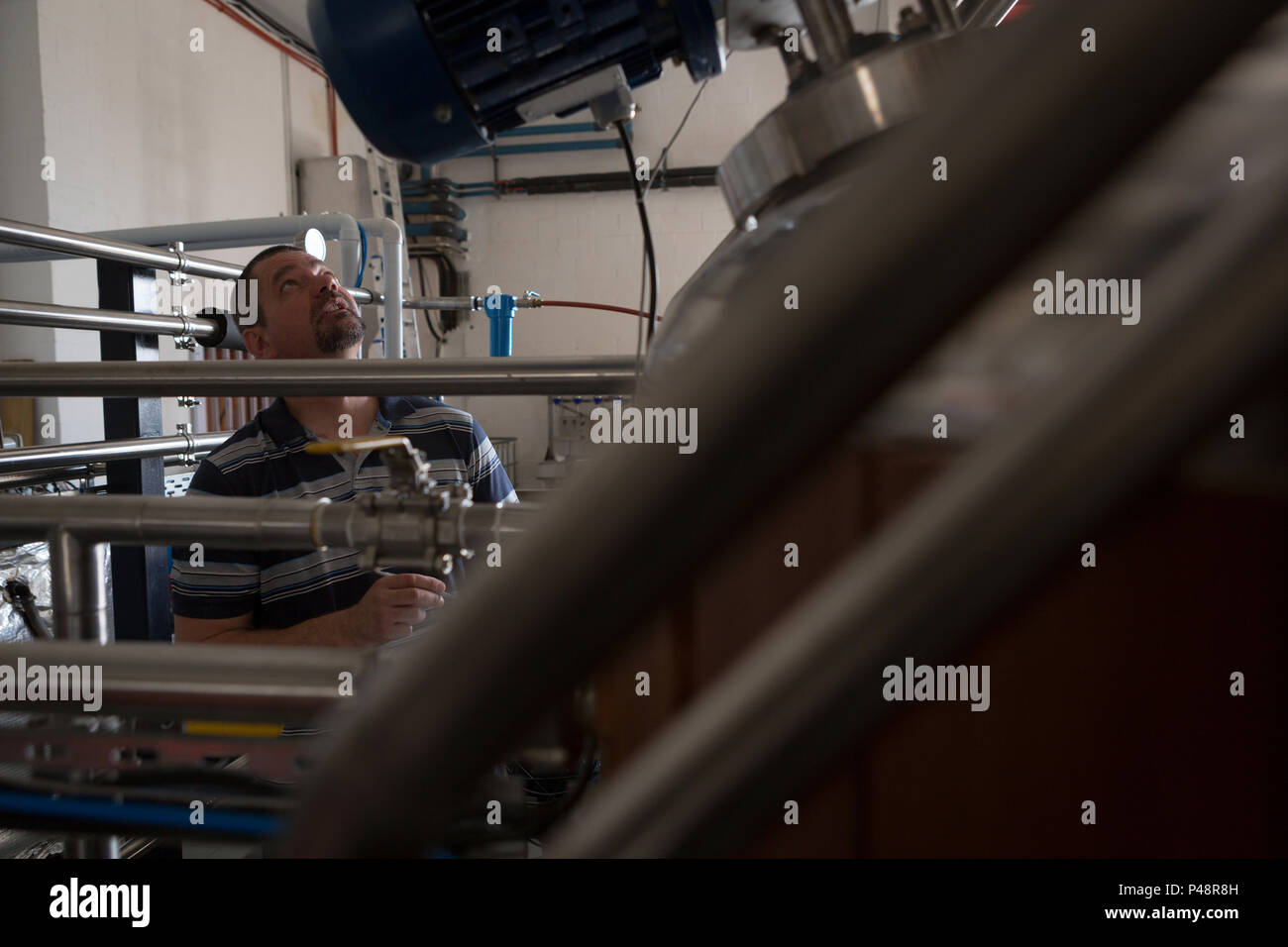 Male worker monitoring a storage tank Stock Photo - Alamy