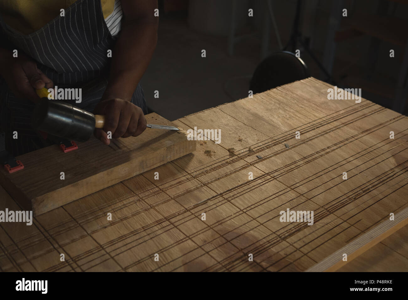 Mid section of carpenter carving wood at table Stock Photo - Alamy