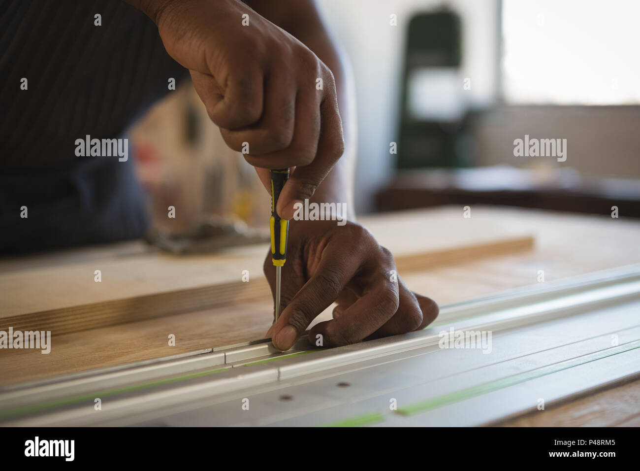 Mid section of carpenter nailing in metal frame Stock Photo - Alamy