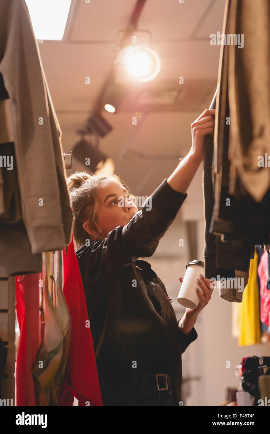 Beautiful woman selecting clothes from rack Stock Photo - Alamy