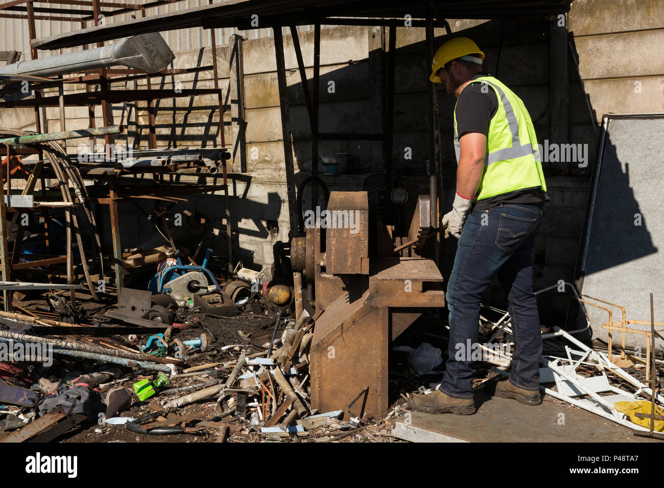 Worker working in scrapyard Stock Photo - Alamy