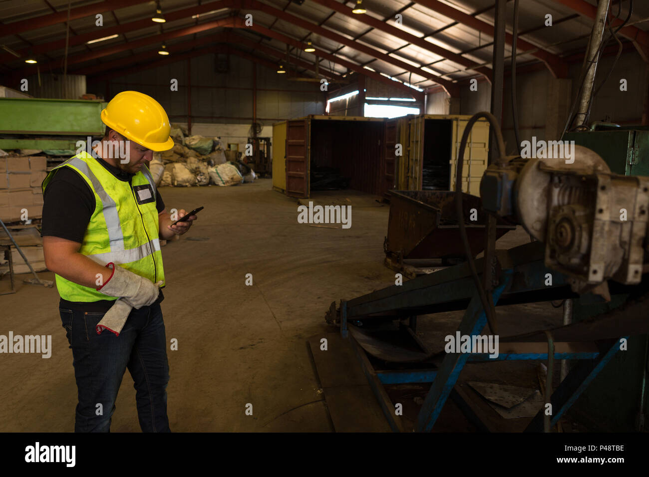 Worker using his mobile phone in the scrapyard Stock Photo - Alamy