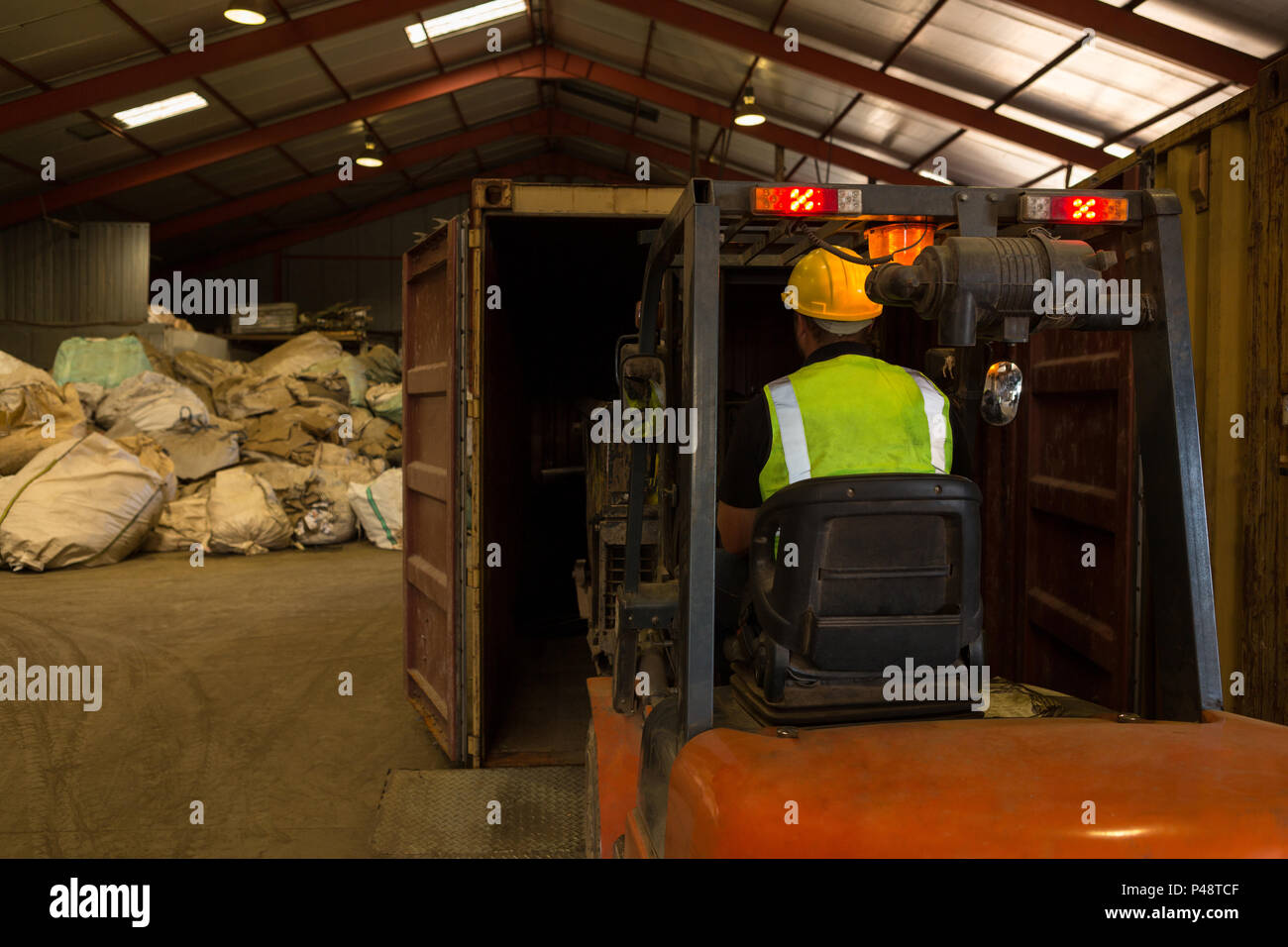 Worker driving a forklift in the junkyard Stock Photo - Alamy