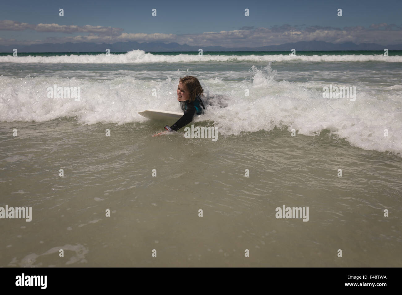 Girl surfing in sea Stock Photo - Alamy