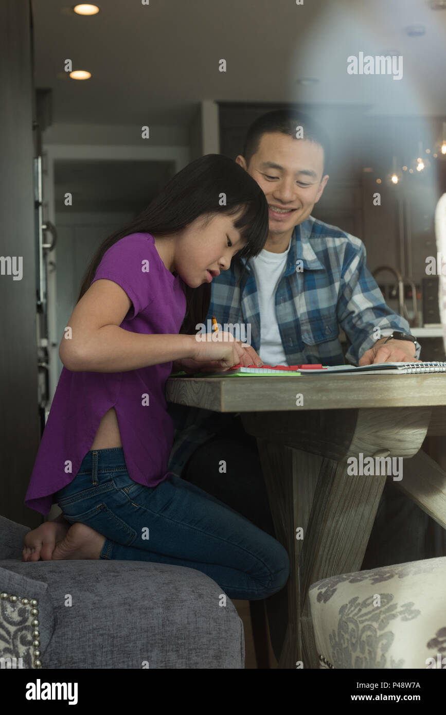 Father assisting her daughter in doing homework Stock Photo - Alamy