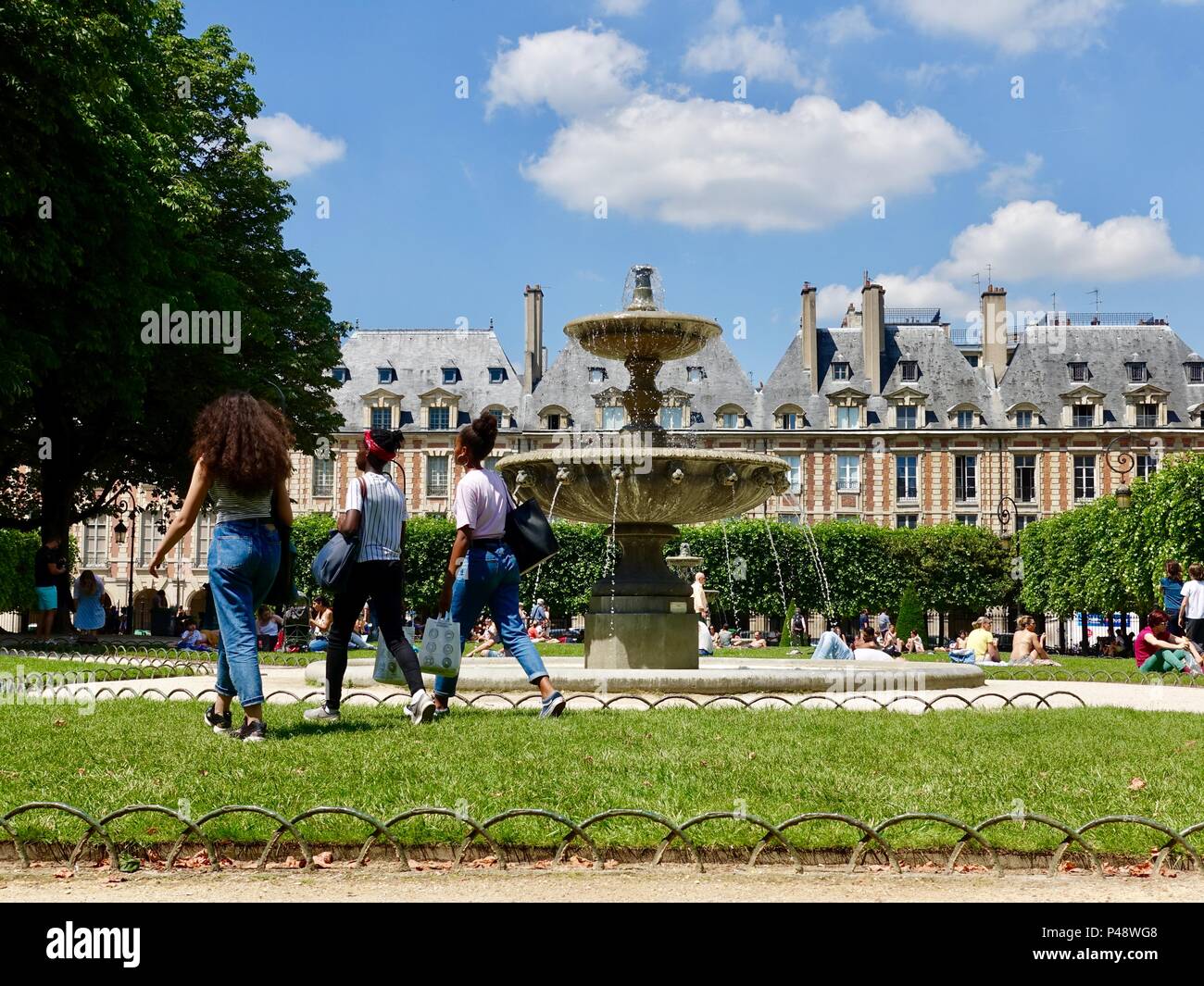 People relaxing at Place des Vosges on a warm June day, Paris, France ...