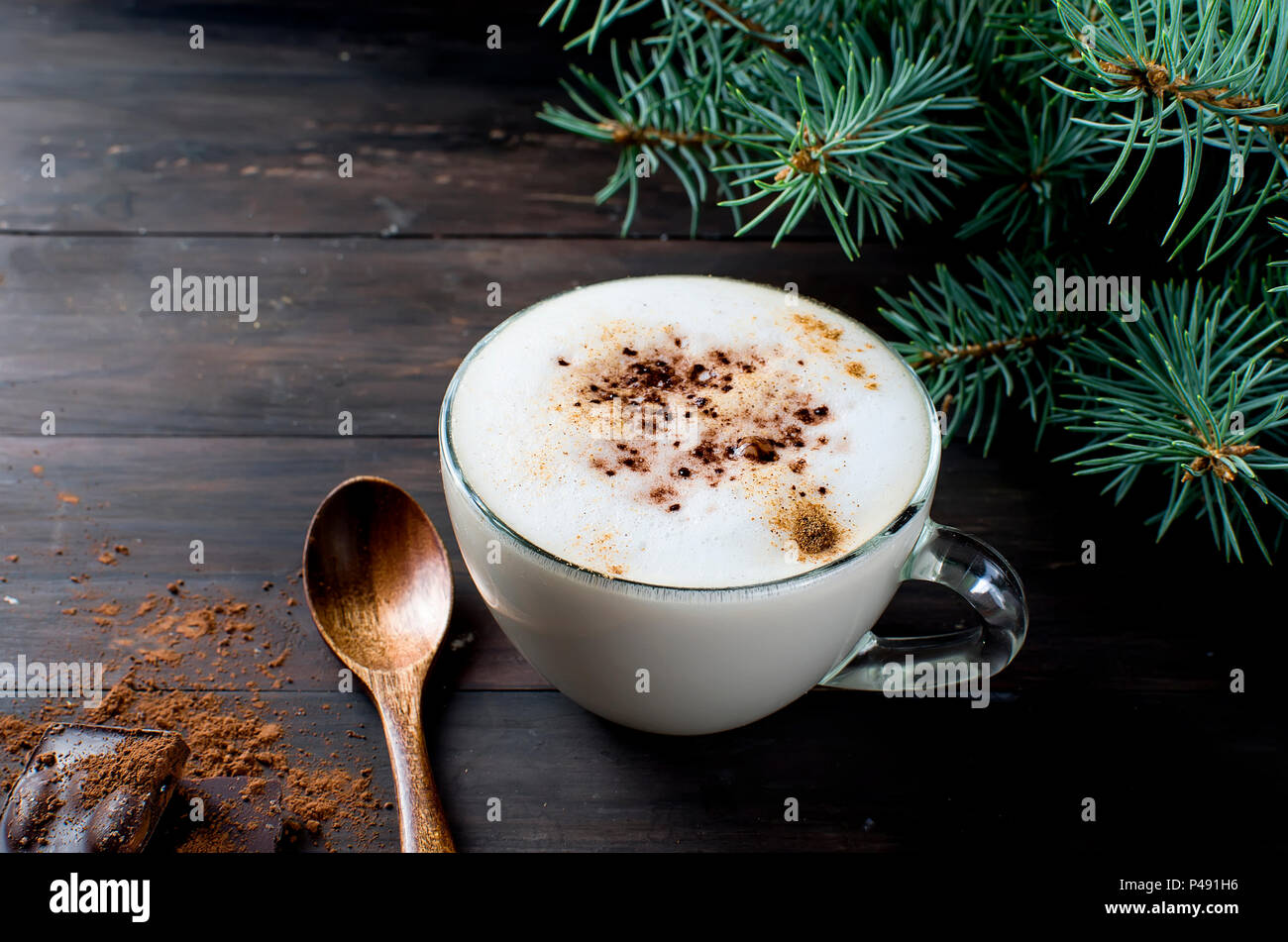 cup of hot cocoa or hot coffee latte with cinnamon, fir tree and ...