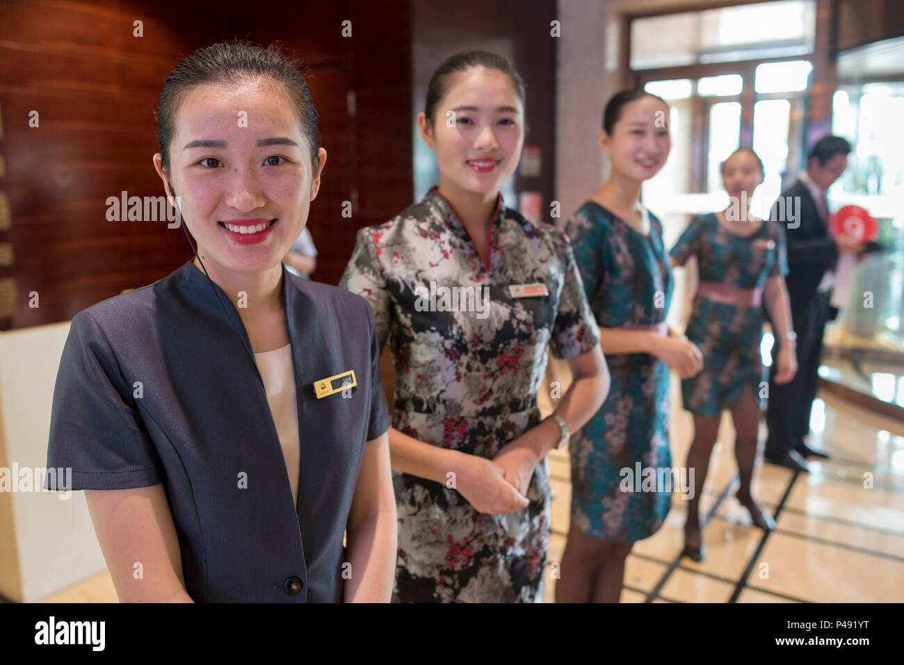 Luxury hotel staff greet foreign visitors in lobby, Beijing, China ...