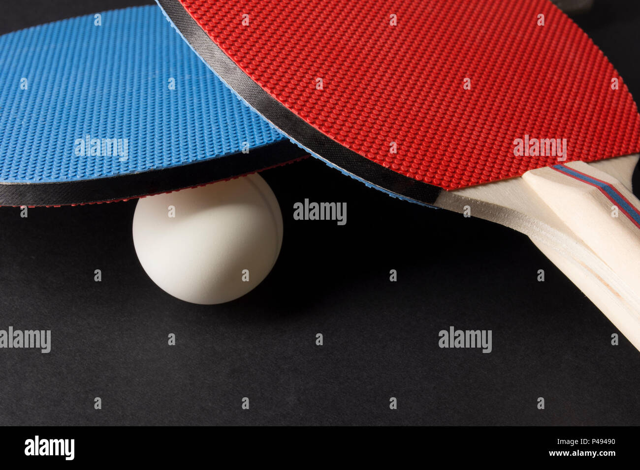 Closeup of Red and Blue Ping Pong Paddles on a Black surface Stock ...