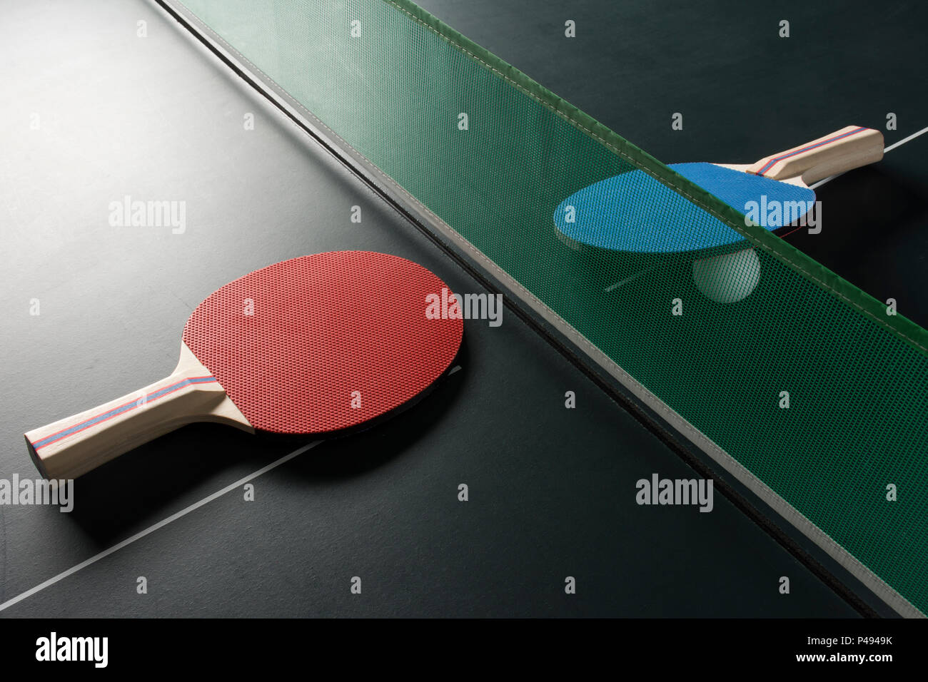 Ping Pong Paddles on a Ping Pong Table, showing the Net with Harsh ...