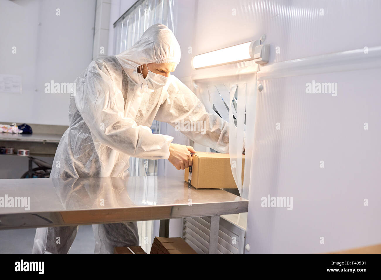 Factory worker taking ready package with product Stock Photo - Alamy