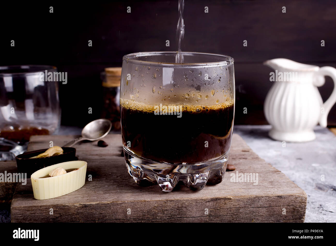 pouring boiling water into a glass of coffee chocolate candy and grains ...