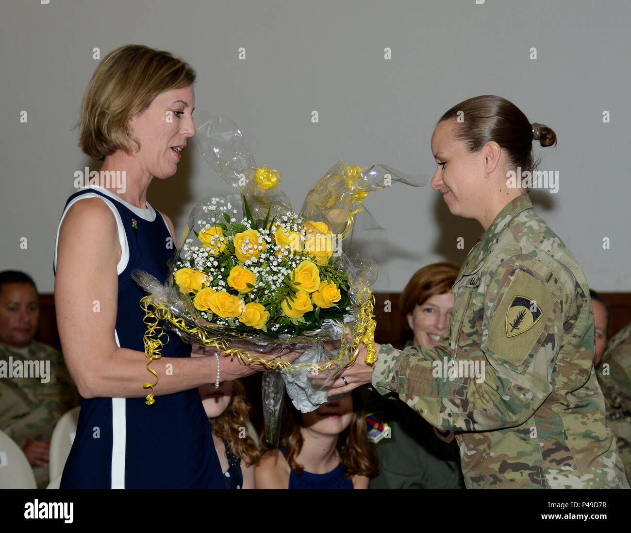 Sgt. Getty Ballard is presenting Mrs. Kelly Lee a bouquet of yellow ...