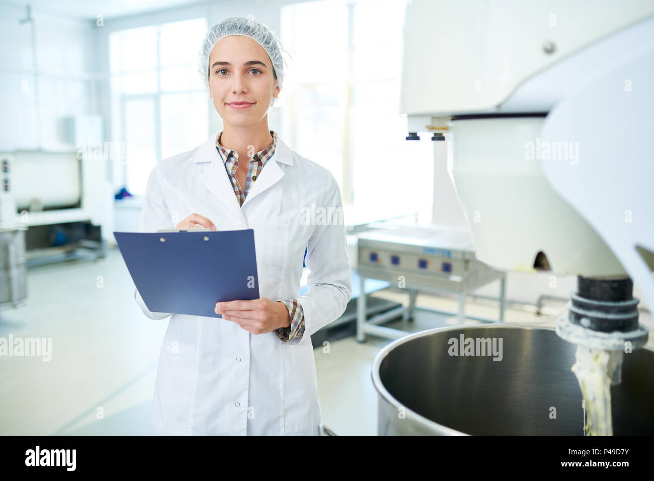 Confectionery factory worker standing with clipboard Stock Photo - Alamy